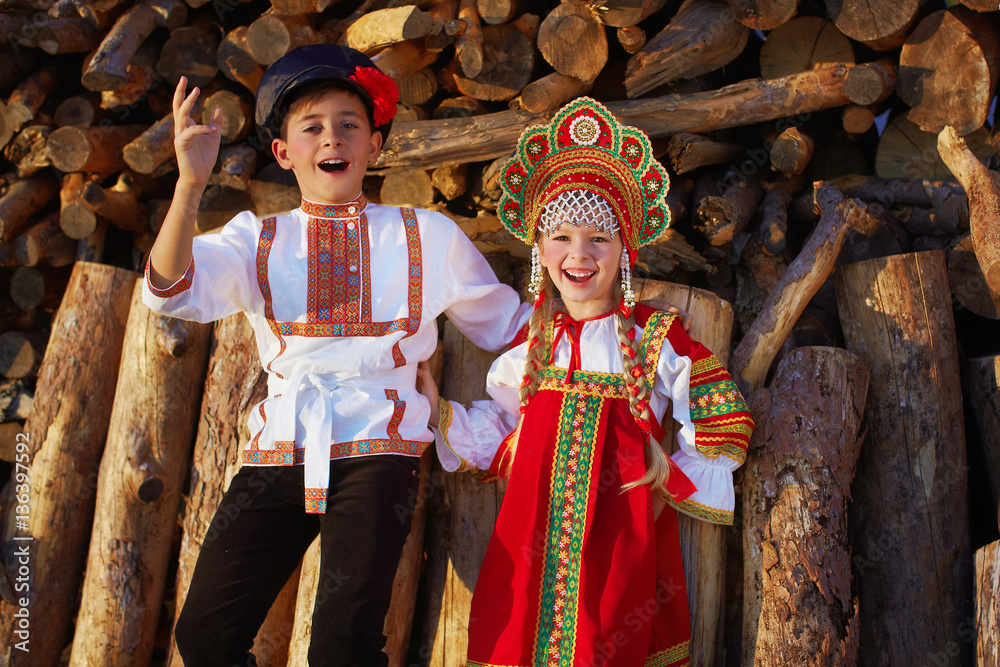Two Russian kids in russian folk costume boy and girl dancing together ...