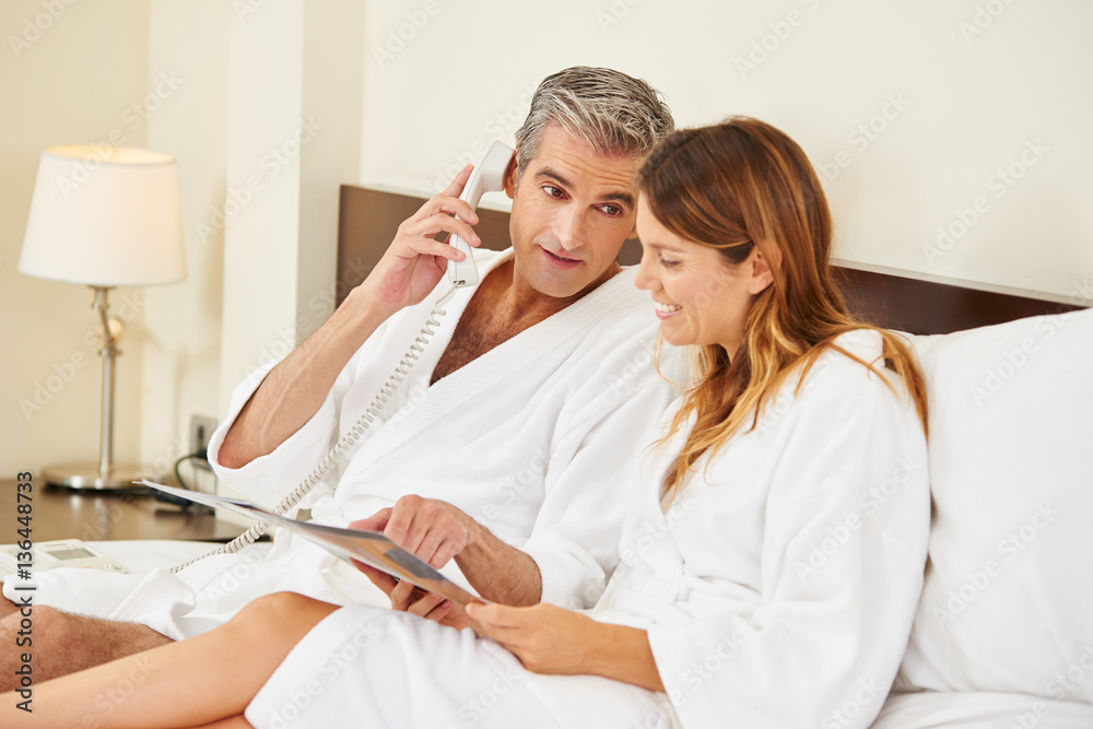 Couple with menu calling room service from hotel Stock Photo | Adobe Stock