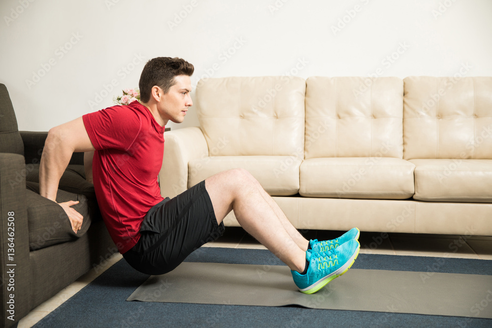 Man doing tricep dips using a couch at home Stock-Foto | Adobe Stock
