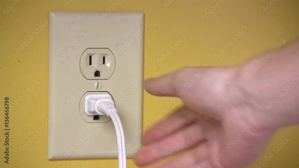 An electrical wall outlet is plugged in and unplugged. This was filmed ...