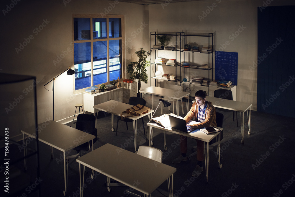 High angle view of student learning through laptop computer in library ...