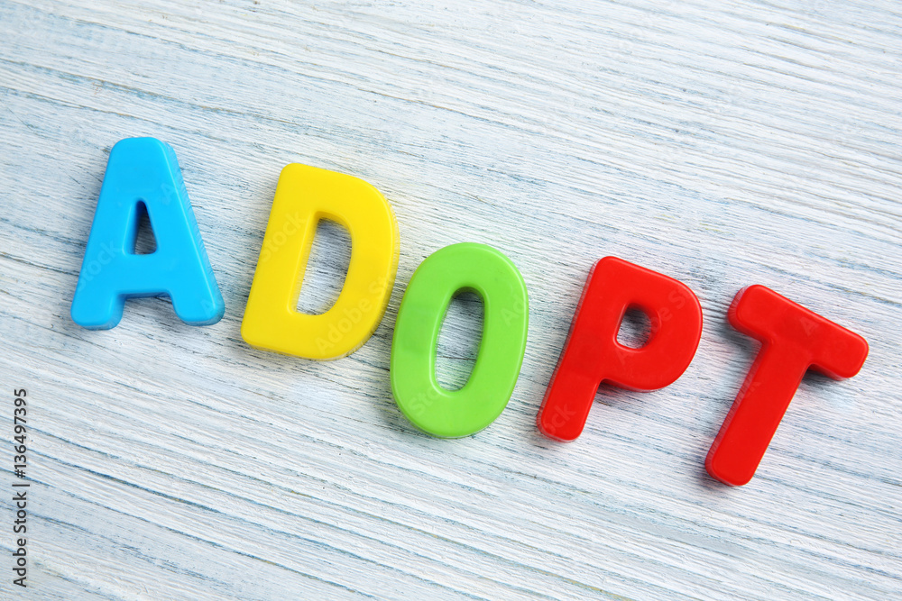 Word ADOPT on light wooden background Stock-Foto | Adobe Stock