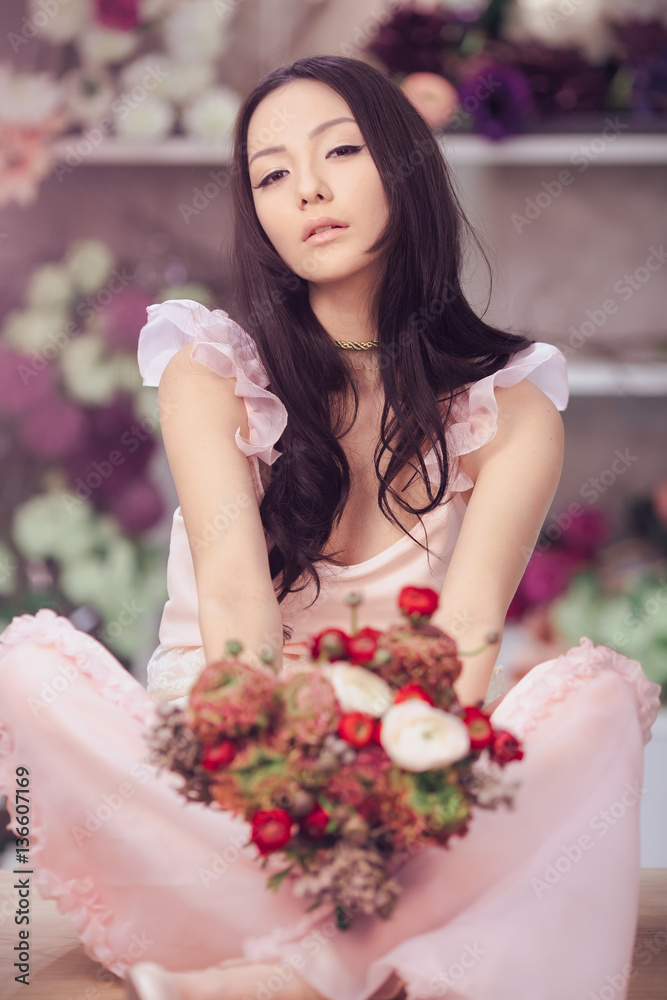 Beautiful asian woman florist in pink dress with bouquet of flowers in ...