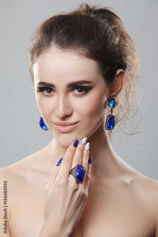 Portrait of beautiful fashion model with bijouterie. Ear-rings, finger ...