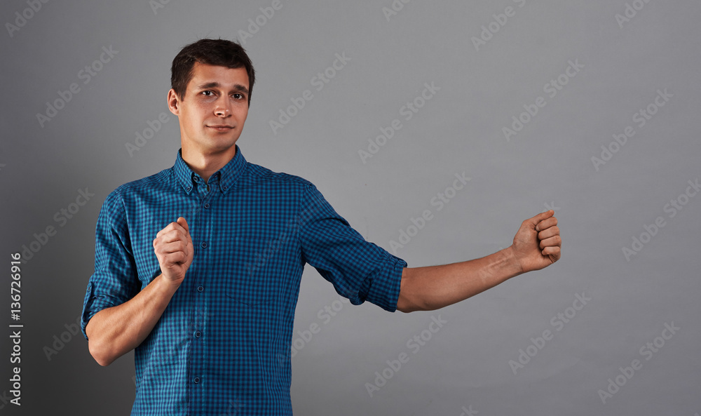 Hansome student with open hands for product or poster. Studio portrait ...