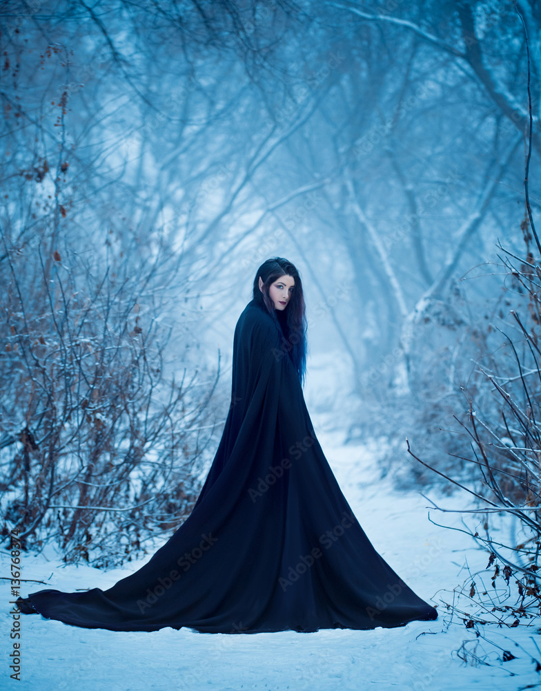 The girl a demon walks alone. She is wearing a long, black traveling ...