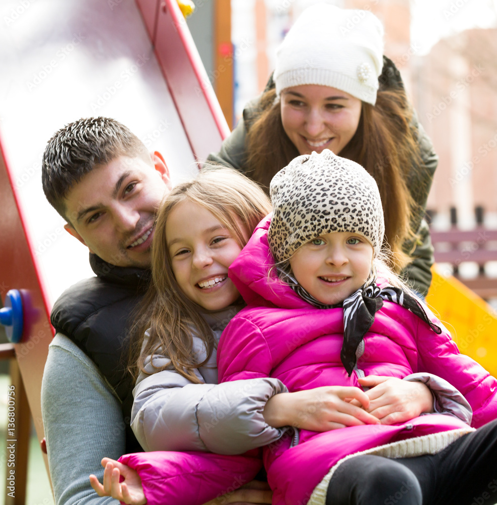 Happy family of four at children's playground foto de Stock | Adobe Stock