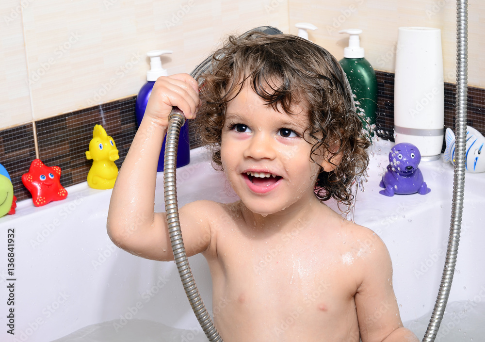 Beautiful toddler taking a bath in a bathtub with bubbles. Cute kid ...