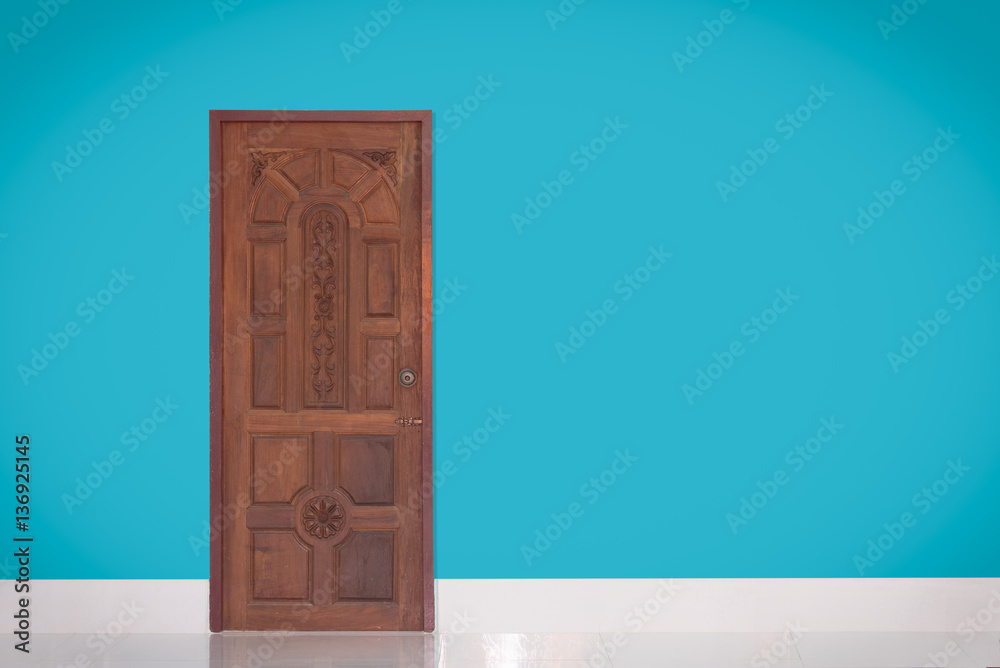 Close up of closed modern bright wooden door on blue background. Blank ...