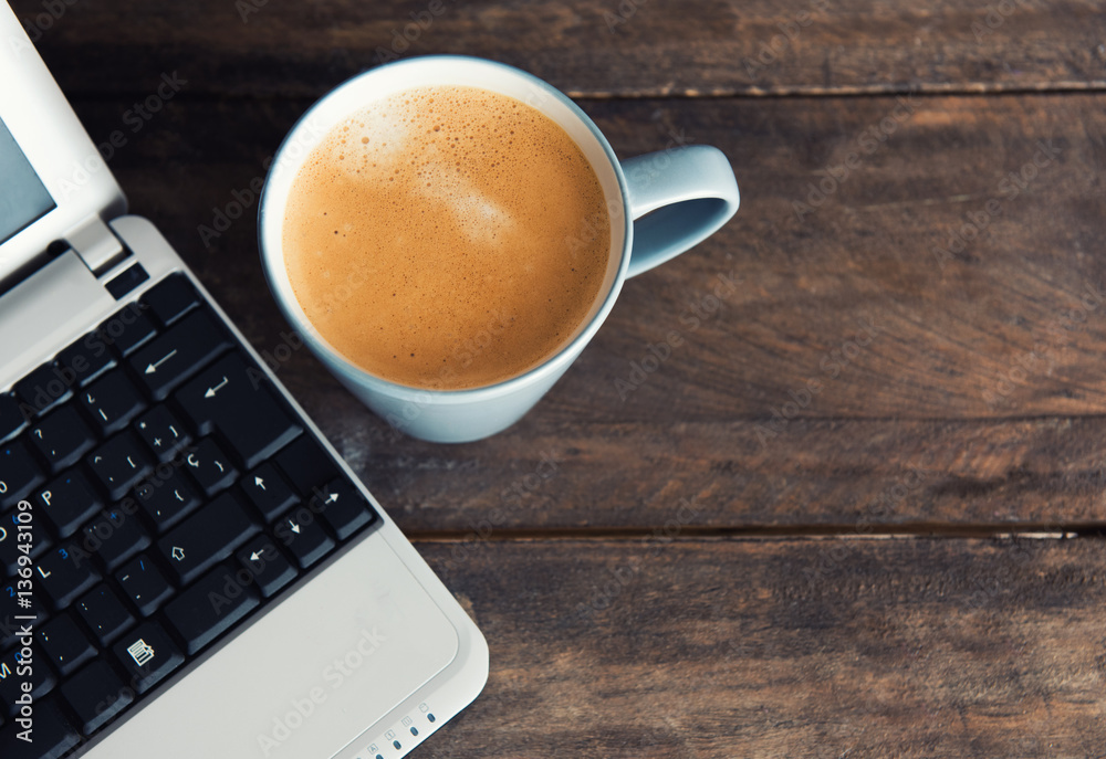cup of coffee next to a small computer Stock Photo | Adobe Stock
