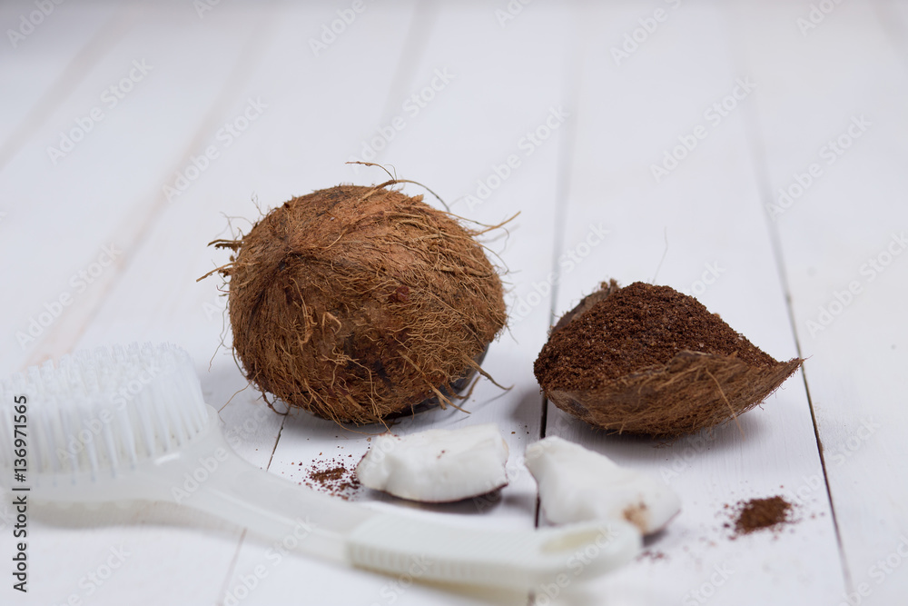 brown granular scrub in a jar and in the shell of the coconut slices on ...
