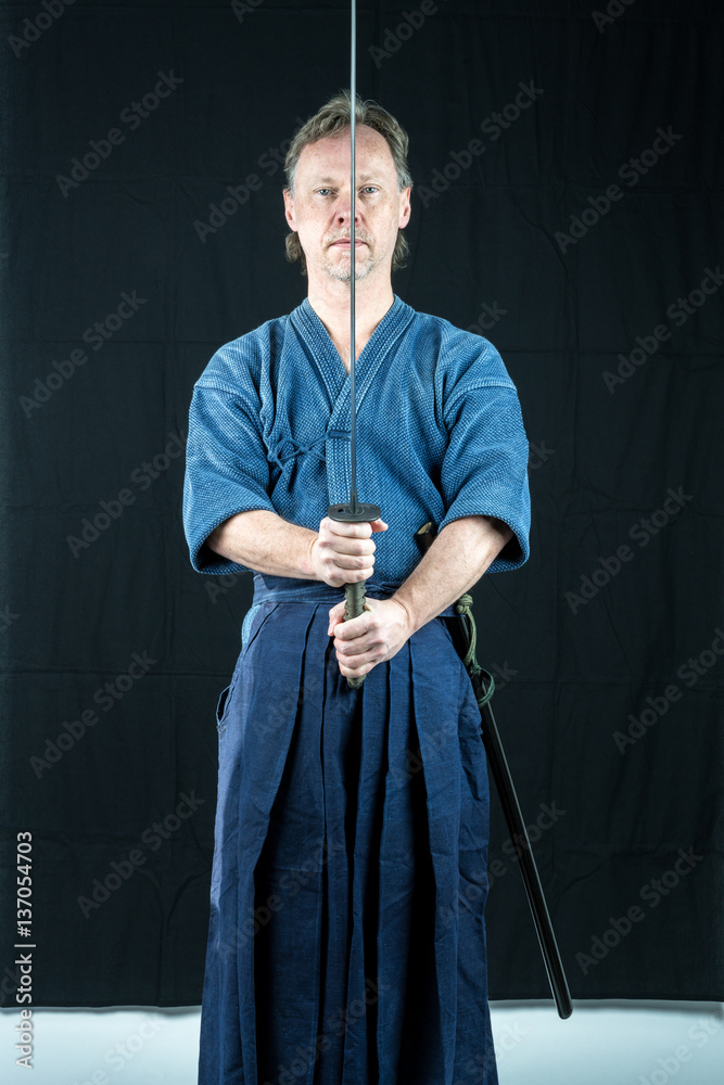 Adult caucasian male training Iaido holding a Japanese sword with ...