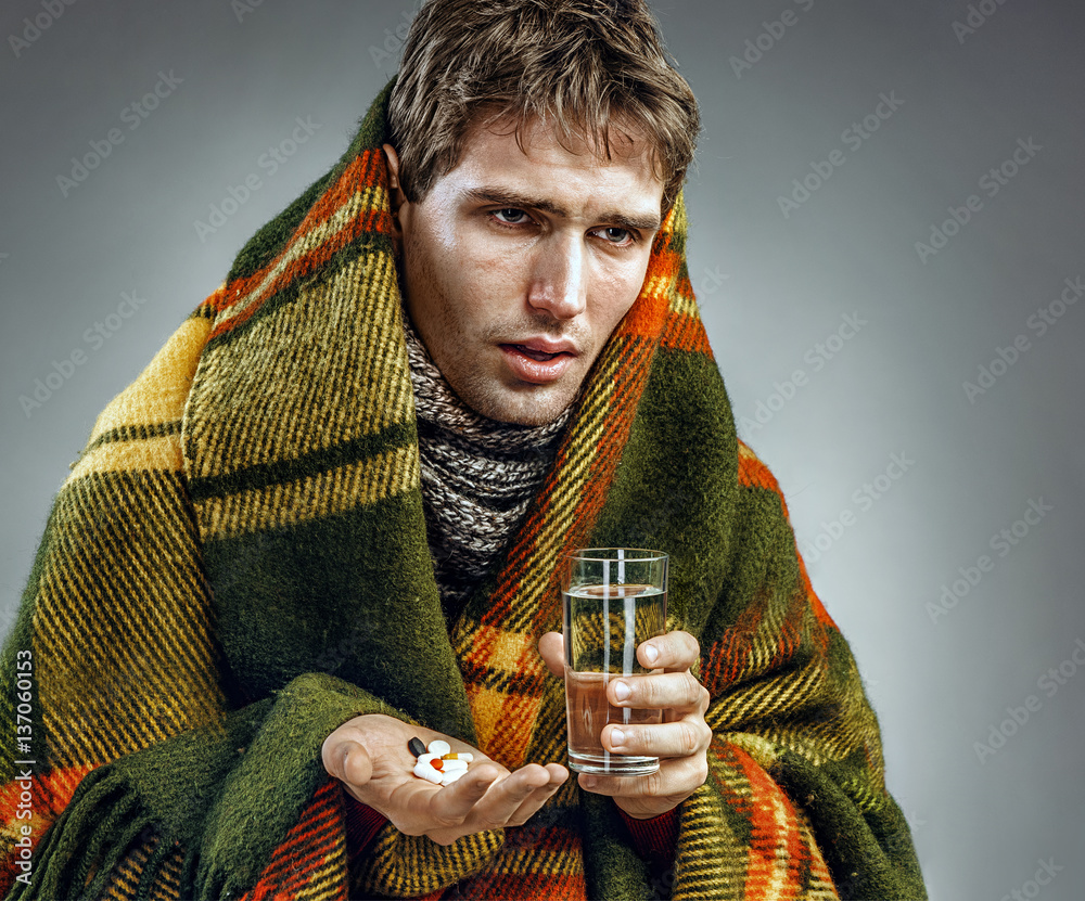 Sick man with tired face expression, taking medicine tablets. Photo of ...