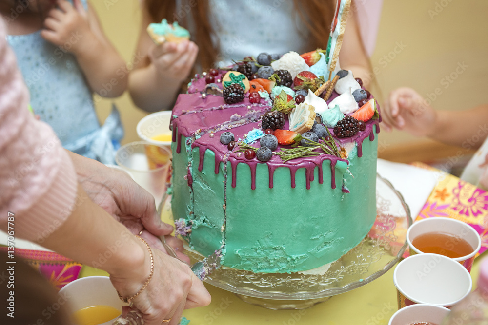 Birthday cake cut with a knife into pieces with bright interiors Stock ...