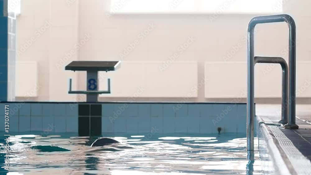 Vidéo Stock Male swimmer gets out of the pool on step ladder after ...