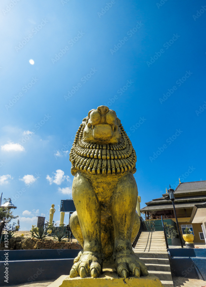 Brave Lion Posture sitting Statue on a mountain view top cliff with sun ...