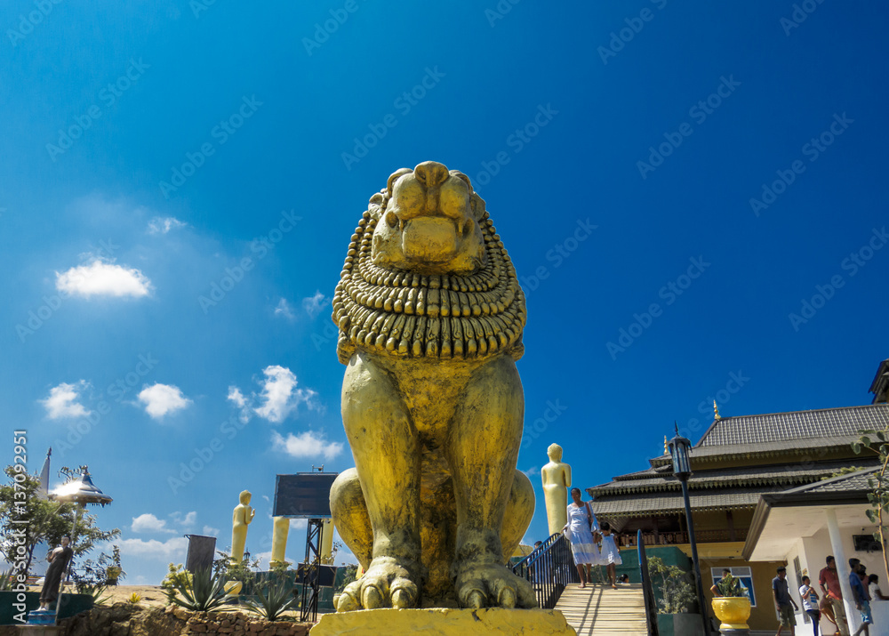 Brave Lion Posture sitting Statue on a mountain view top cliff with sun ...