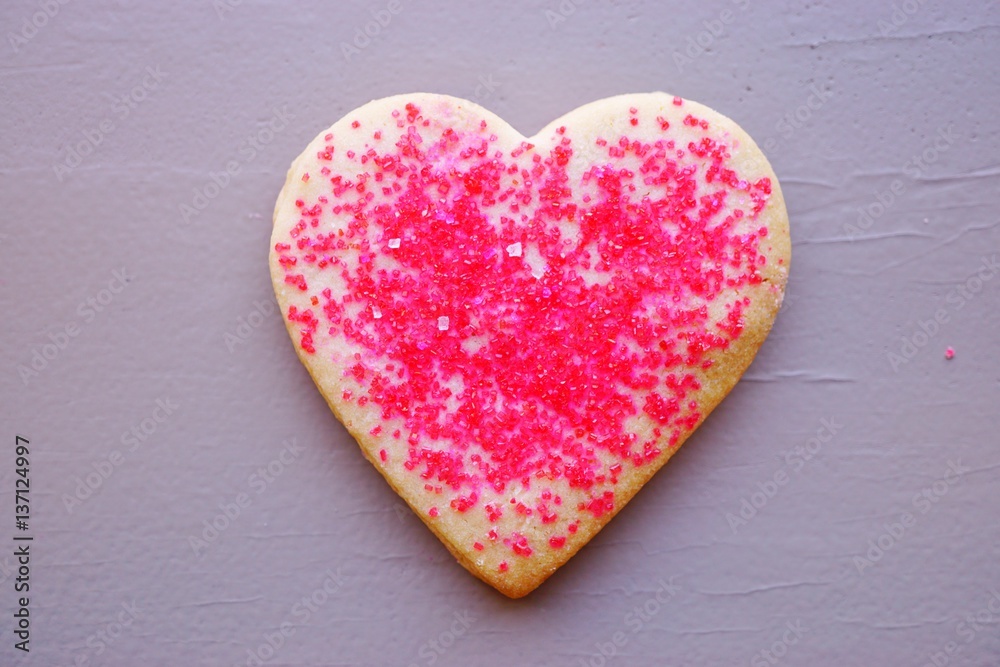 A heart shaped sugar cookie with red and pink sprinkles for Valentine's ...