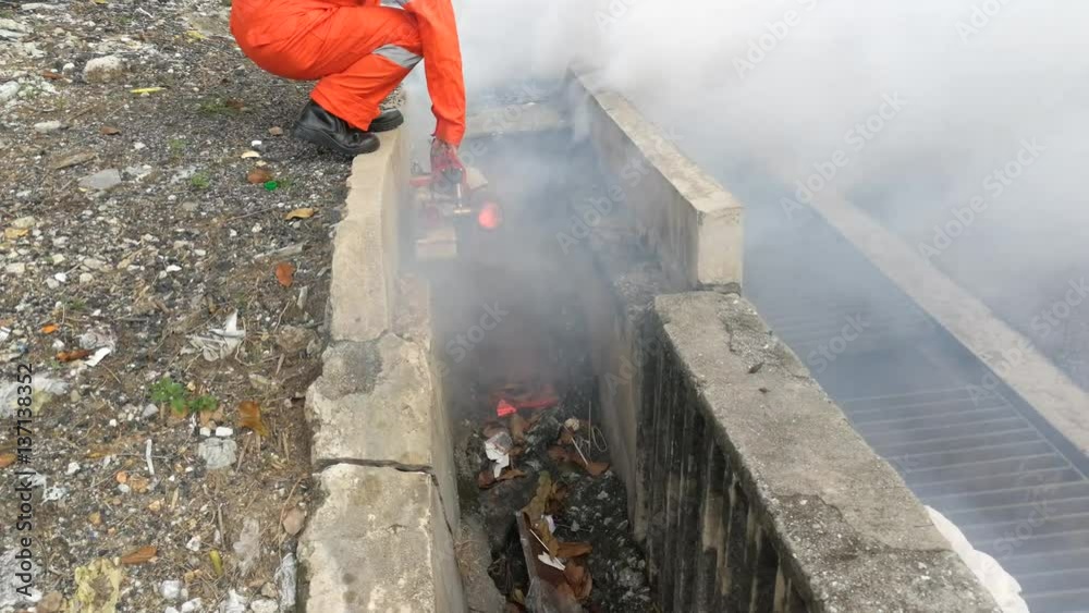 Worker fogging drain with insecticides to kill aedes mosquito breeding ...