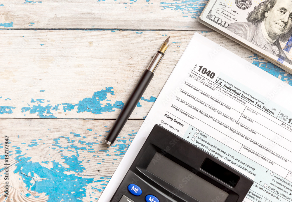 Money, calculator and tax form on the old blue table. Business concept ...