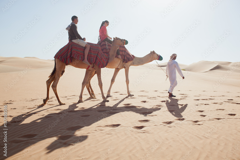 Couple riding on camel at desert. Stock Photo | Adobe Stock