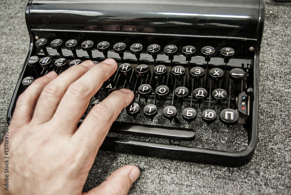 Old typerwiter with cyrillic letters on grey floor background with ...
