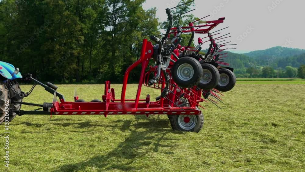 The machinery for preparing hay is slowly folding together and both ...