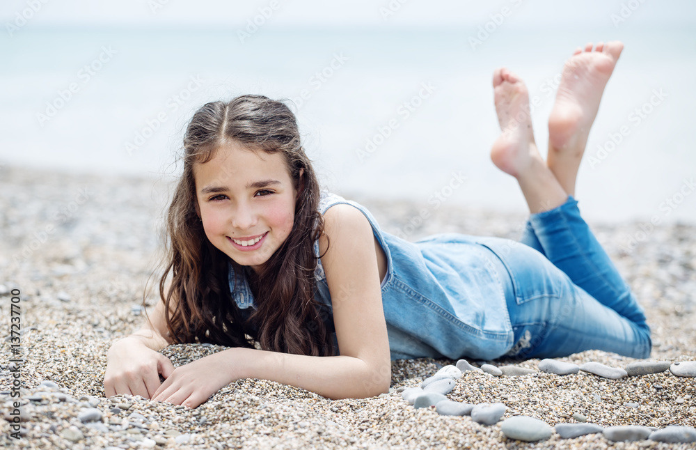 Happy little girl lying on the beach Stock Photo | Adobe Stock Happy little girl lying on the beach Stock Photo | Adobe Stock