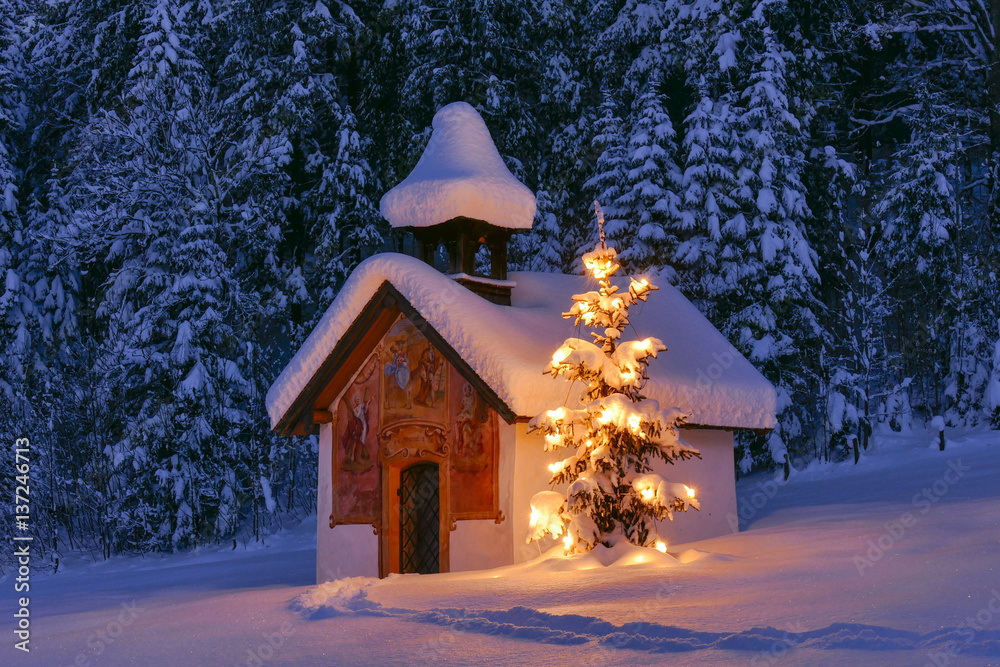 Illuminated Christmas tree in front of a chapel in winter, Bavaria ...