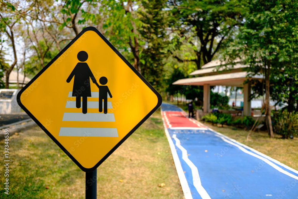 Traffic sign shows symbols of mother and child on pedestrian walkway ...