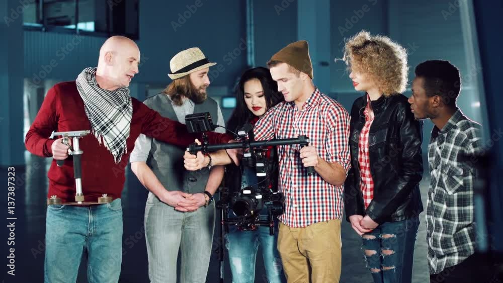 Man testing handheld camera gyro stabilizin gimbal, the director shows ...