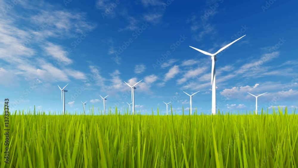 Rotating wind turbines on a field covered with fresh green grass ...