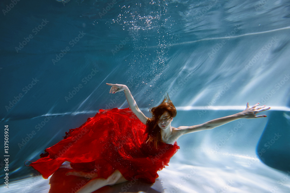 Underwater in the pool with the purest water. Beautiful girl in a ...
