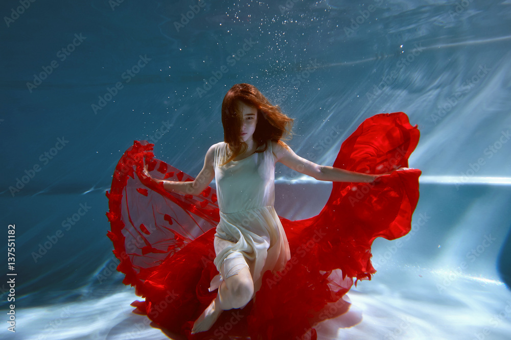 Underwater in the pool with the purest water. Beautiful girl in a ...