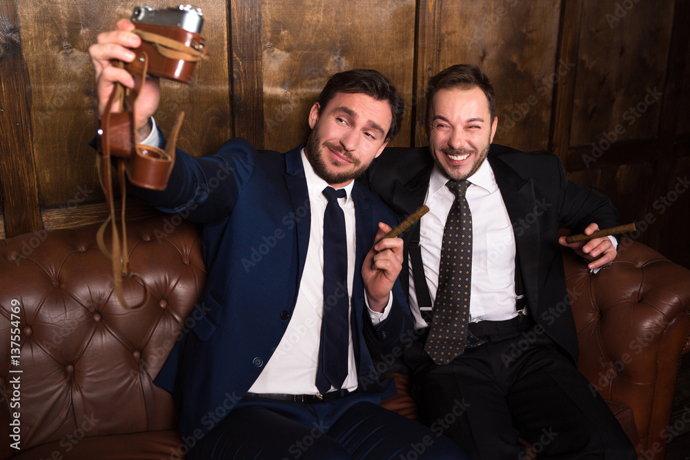 Rich businessmen with cigars making photos while spending time in ...