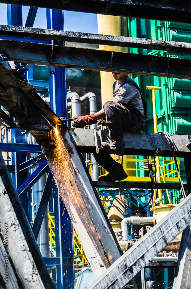 Cutting steel structure. Work at height. Man working on the demolition ...