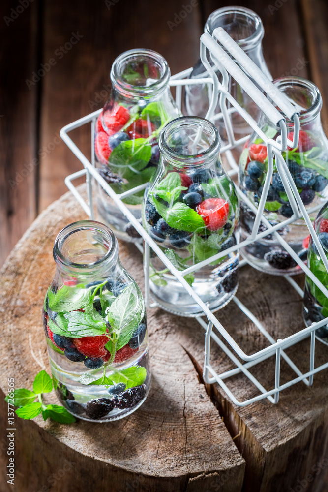 Fruity water in bottle with raspberries, blueberries and blackberries ...