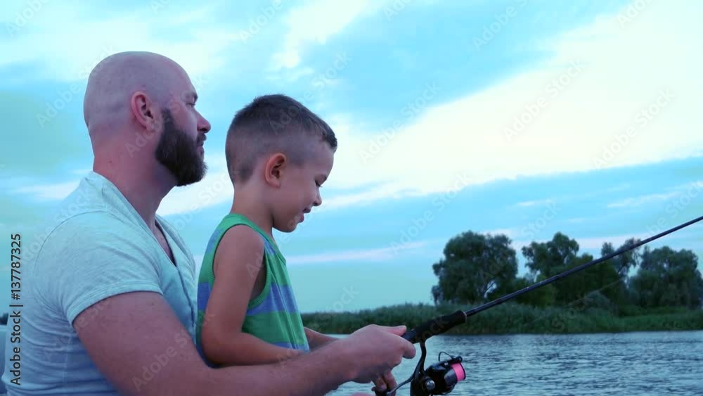 Father and son fishing rod catch a fish sitting in a boat, happy father ...