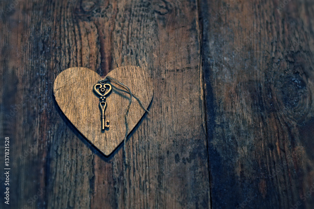 key and wooden heart on rustic wooden background. heart, symbol of love ...