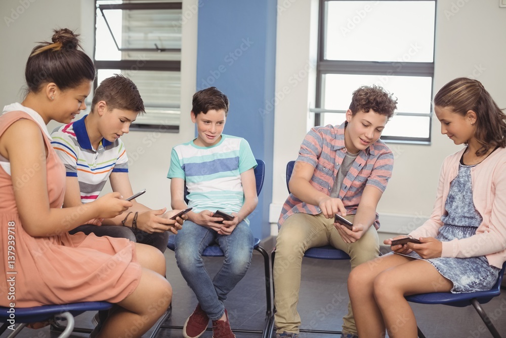 Students using mobile phone in classroom Stock Photo | Adobe Stock