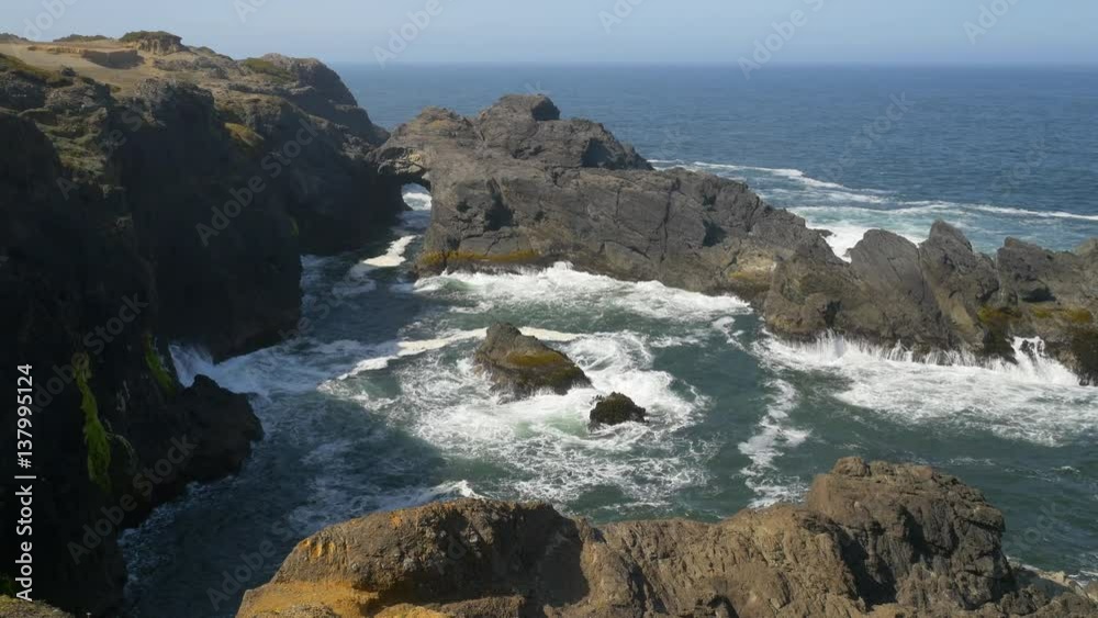 Pan of a narrow bay with an arched hole at Indian Sands in Samuel H ...
