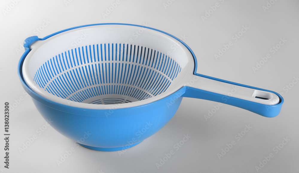 White plastic colander in blue bowl Stock Photo | Adobe Stock