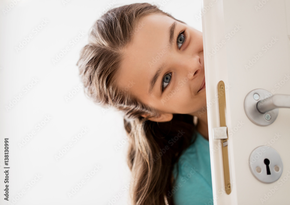 happy smiling beautiful girl behind door at home Stock-Foto | Adobe Stock