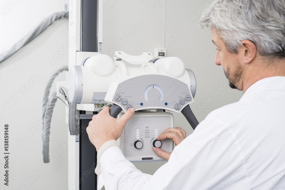 Male Radiologist Adjusting The Controls On X-ray Machine Stock Photo ...