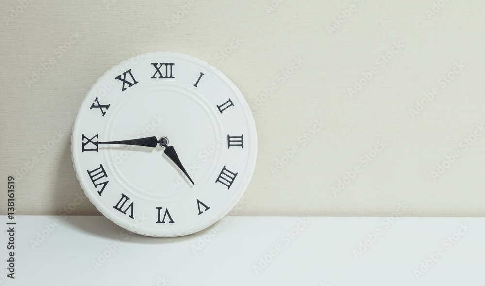 Closeup white clock for decorate show a quarter to five p.m. or 4:45 p ...