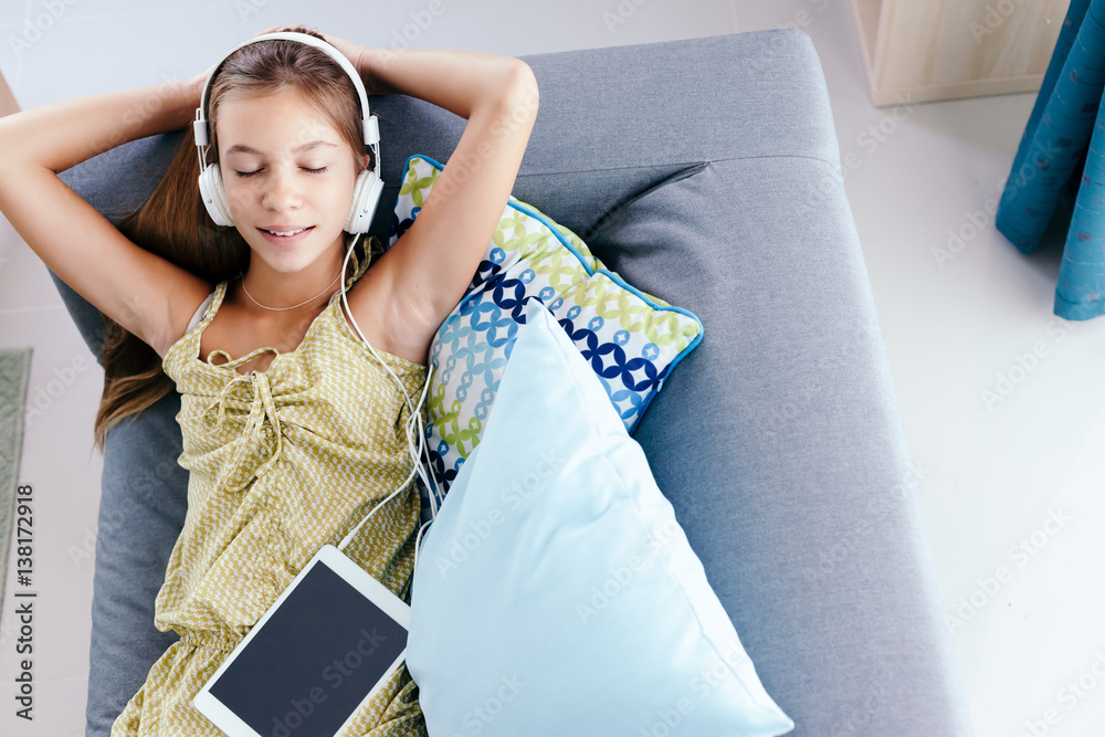 Tween girl relaxing on couch at home Stock Photo | Adobe Stock