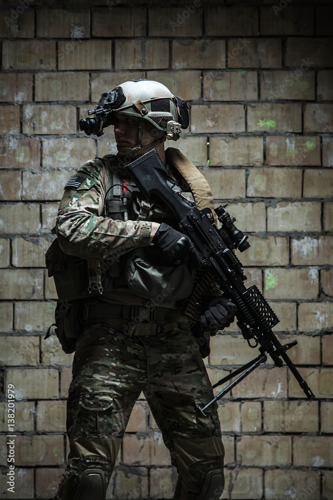 US Army Ranger with machinegun and night vision goggles standing near ...