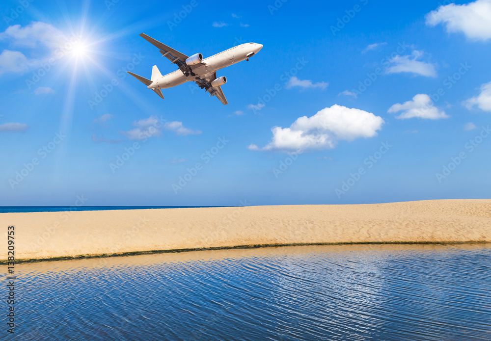 passenger airplane landing above tropical beach in andaman sea on blue ...