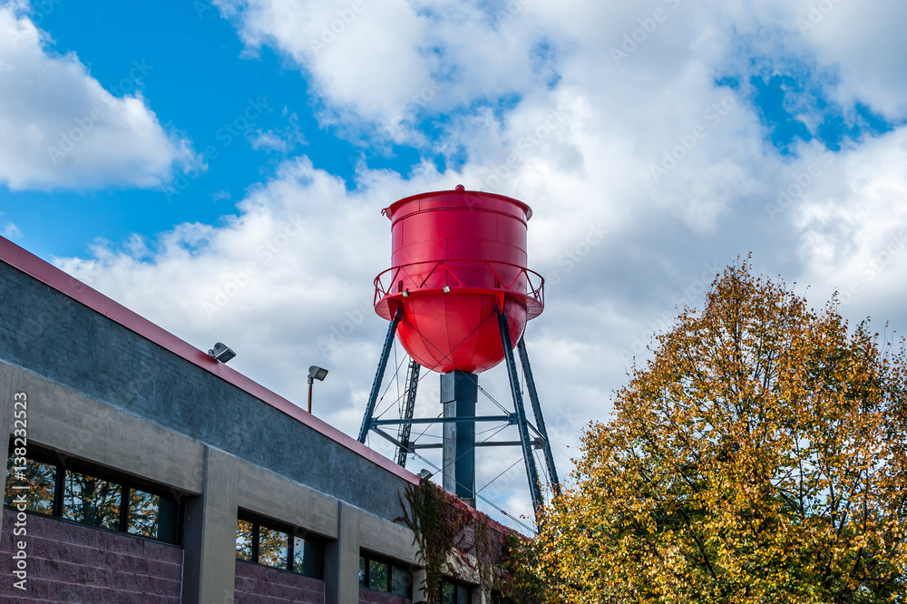 Industrial building with water reserve on roof. red water tower on top ...