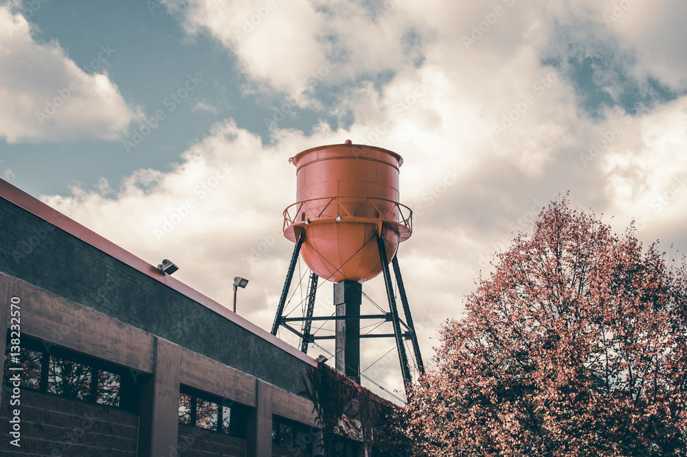 Industrial building with water reserve on roof. red water tower on top ...